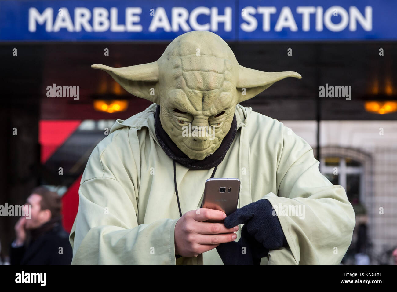 London, UK. 9th Dec, 2017. A floating Yoda street performer checks his ...