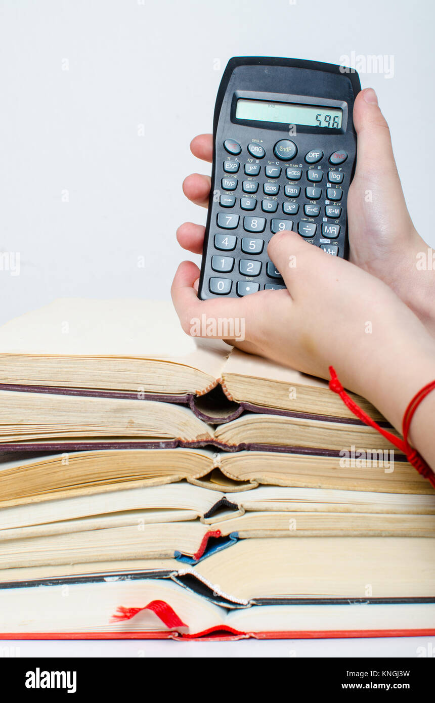 A pile of books and a calculator help in learning Stock Photo - Alamy