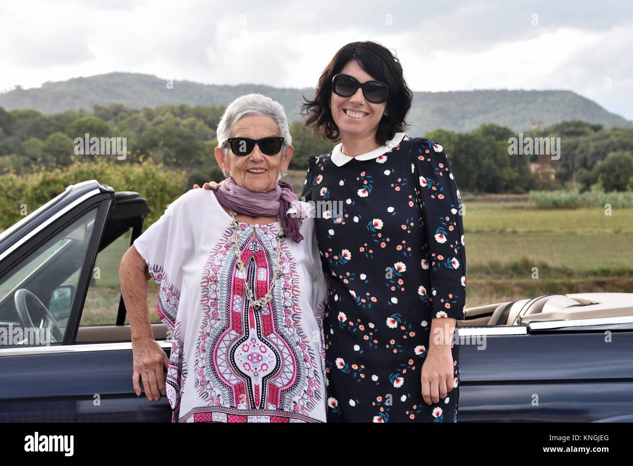 portrait of two women leaning on a car Stock Photo - Alamy
