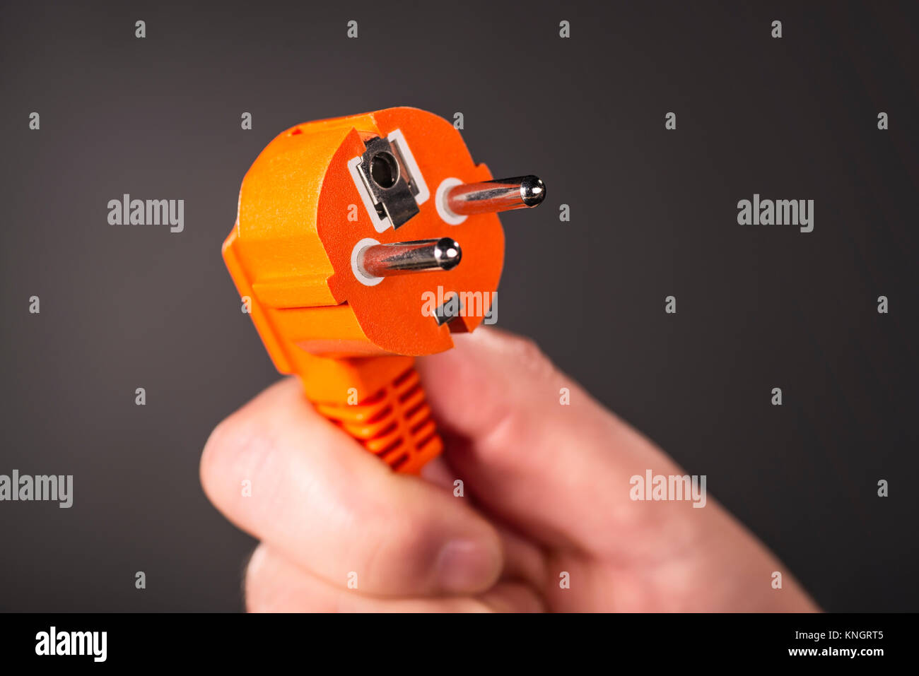 Hand holds an orange plug Stock Photo - Alamy