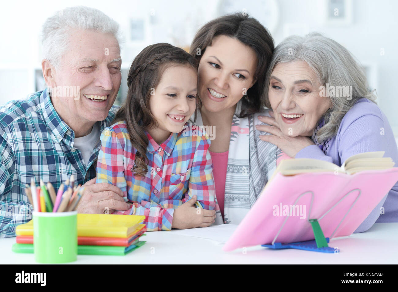 Big family with cute little girl doing homework Stock Photo - Alamy