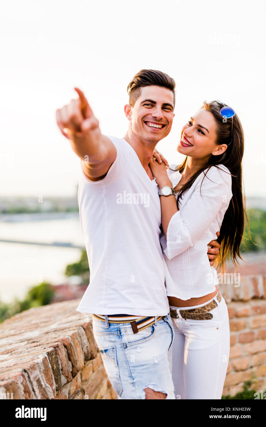 Happy couple pointing in a direction Stock Photo - Alamy