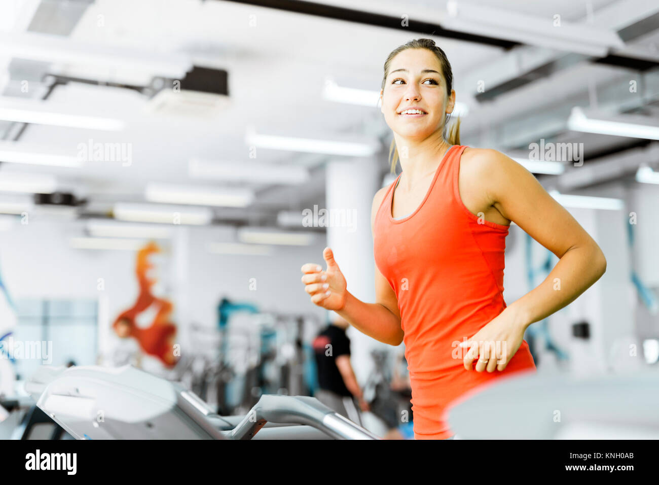 Beautiful young woman running on a treadmill in gym Stock Photo - Alamy