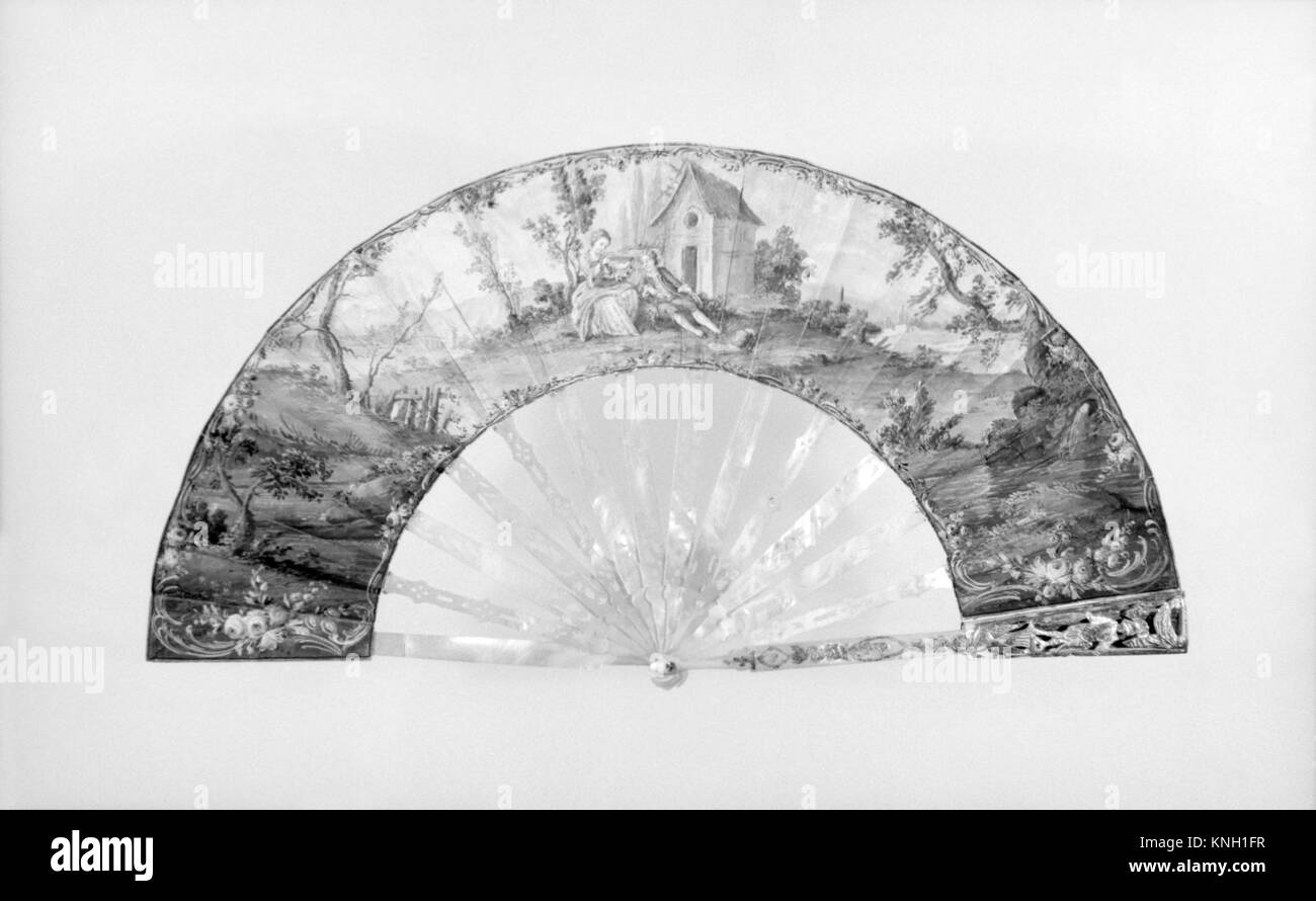 This ornate fan serves as a personal cooling device and decorative ...