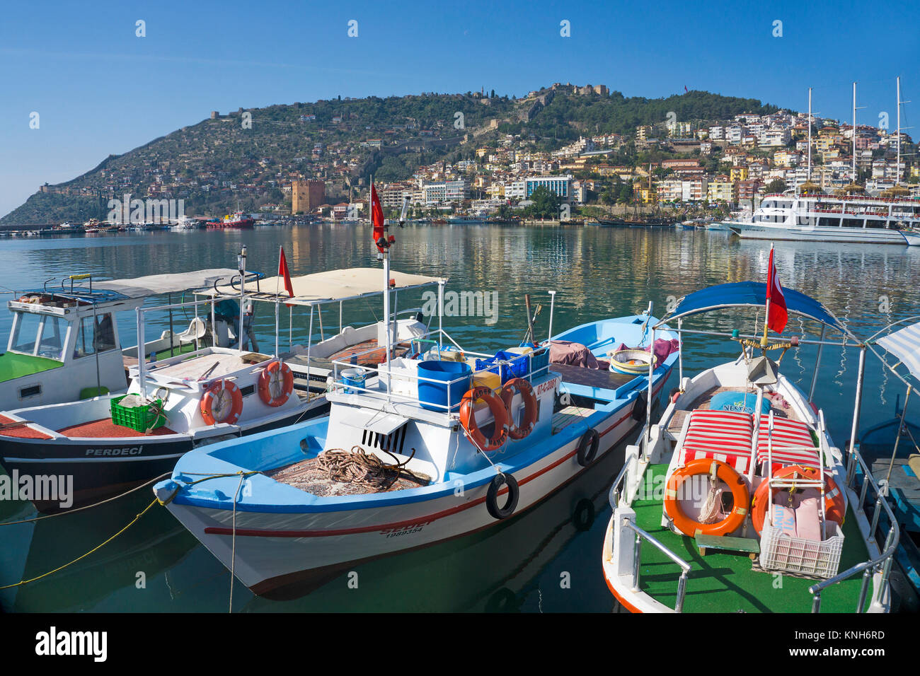 Fishing boats at harbour, behind castle hill with citadel, Alanya ...