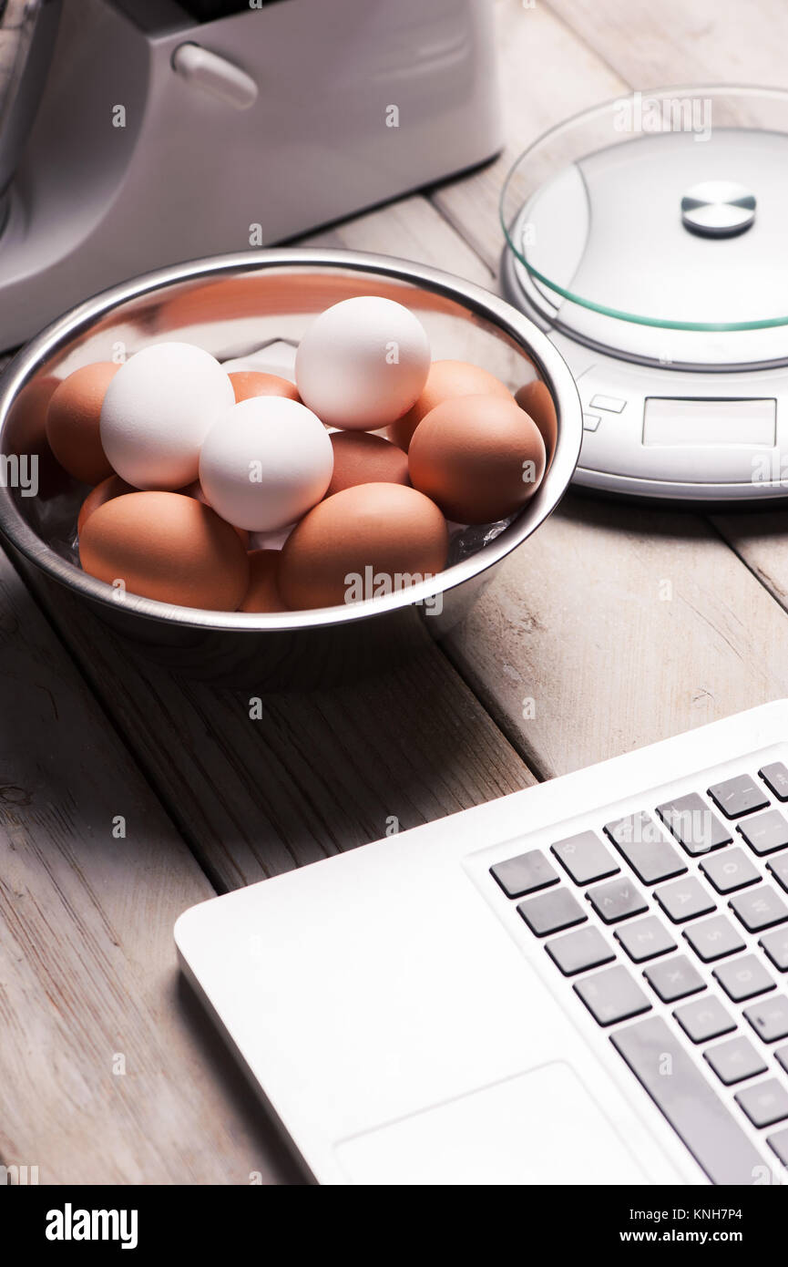 Eggs scale and laptop. On line recipe concept Stock Photo - Alamy