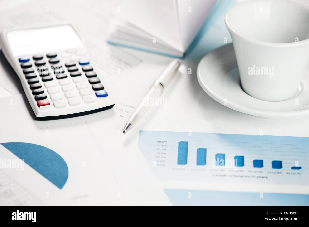 Calculator with financial charts on a table with coffe cup Stock Photo ...