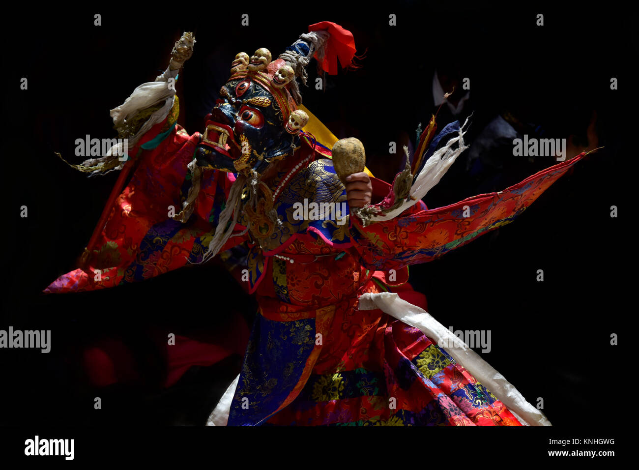Tibetan lama performs the ritual Dance Mask in a bright sacral outfit ...
