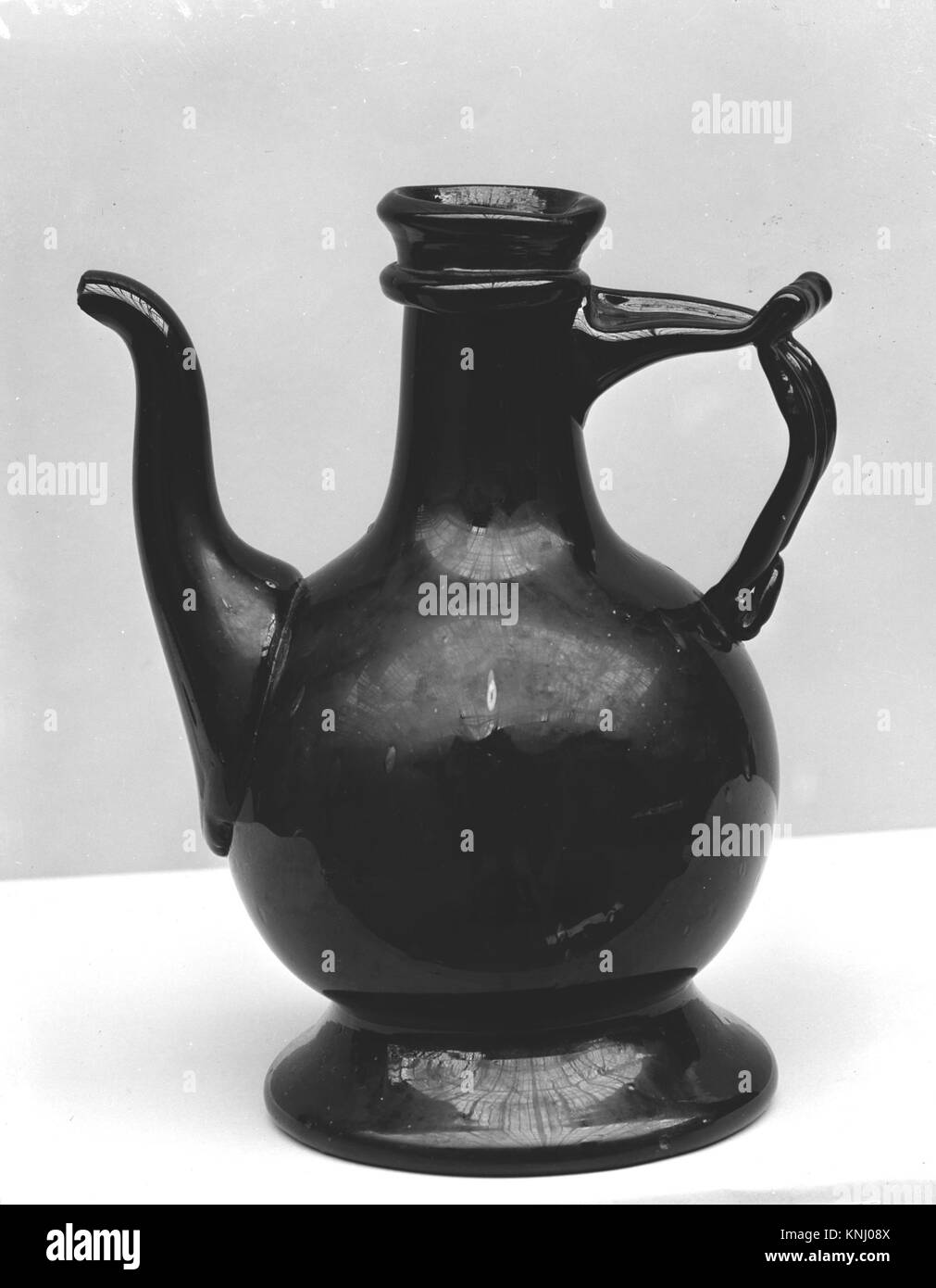 Metal ewer with curved spout and handle, demonstrating functional and ...