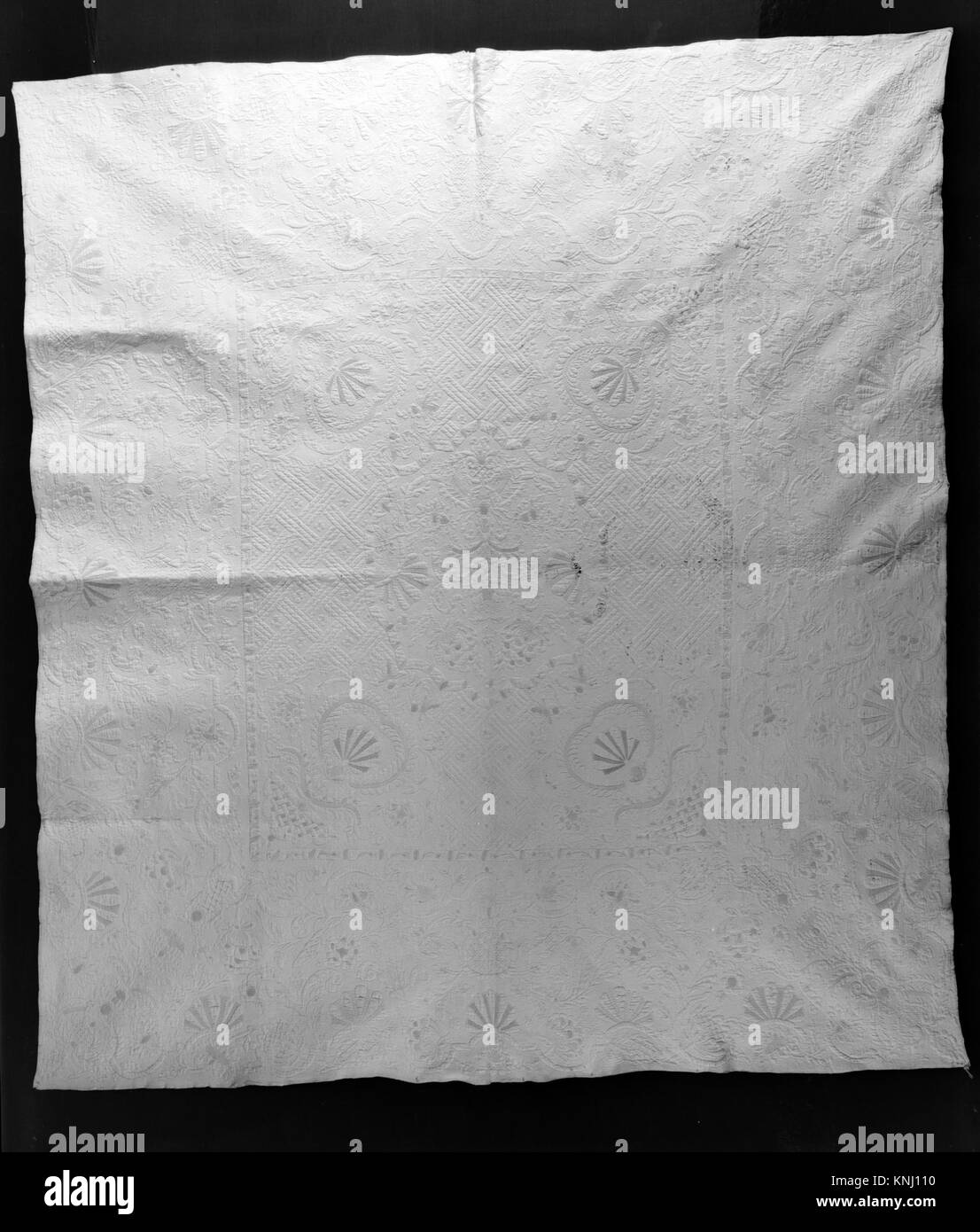 A whitework quilt featuring embroidered and stuffed elements, creating ...