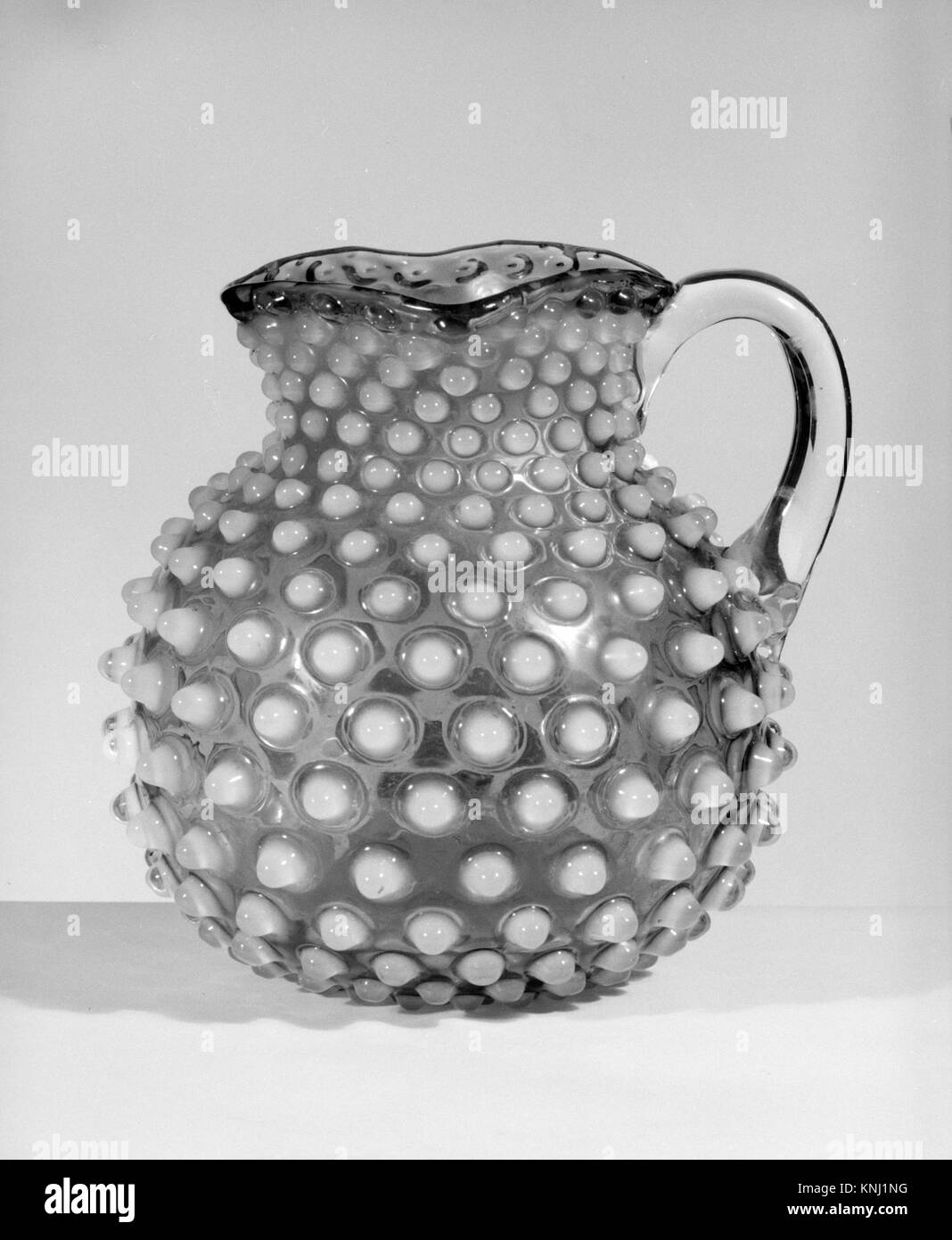 This hobnail pitcher, made from glass, showcases the distinctive ...