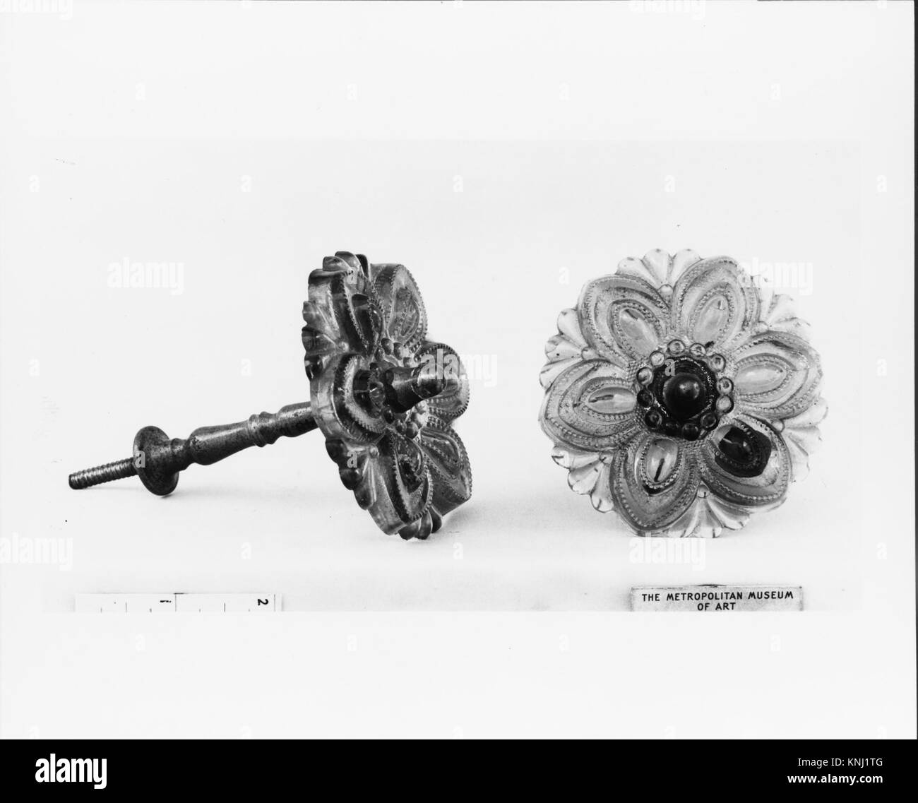 This curtain knob, made of lacy pressed glass and brass, dates from ...