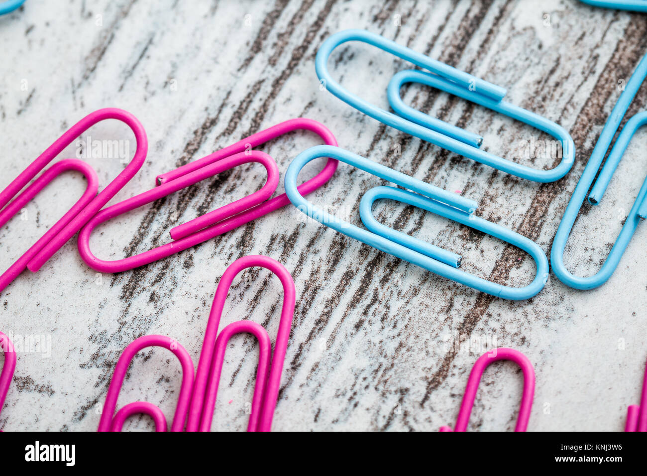 Pink and blue binder paper clips on white wooden background Stock Photo ...