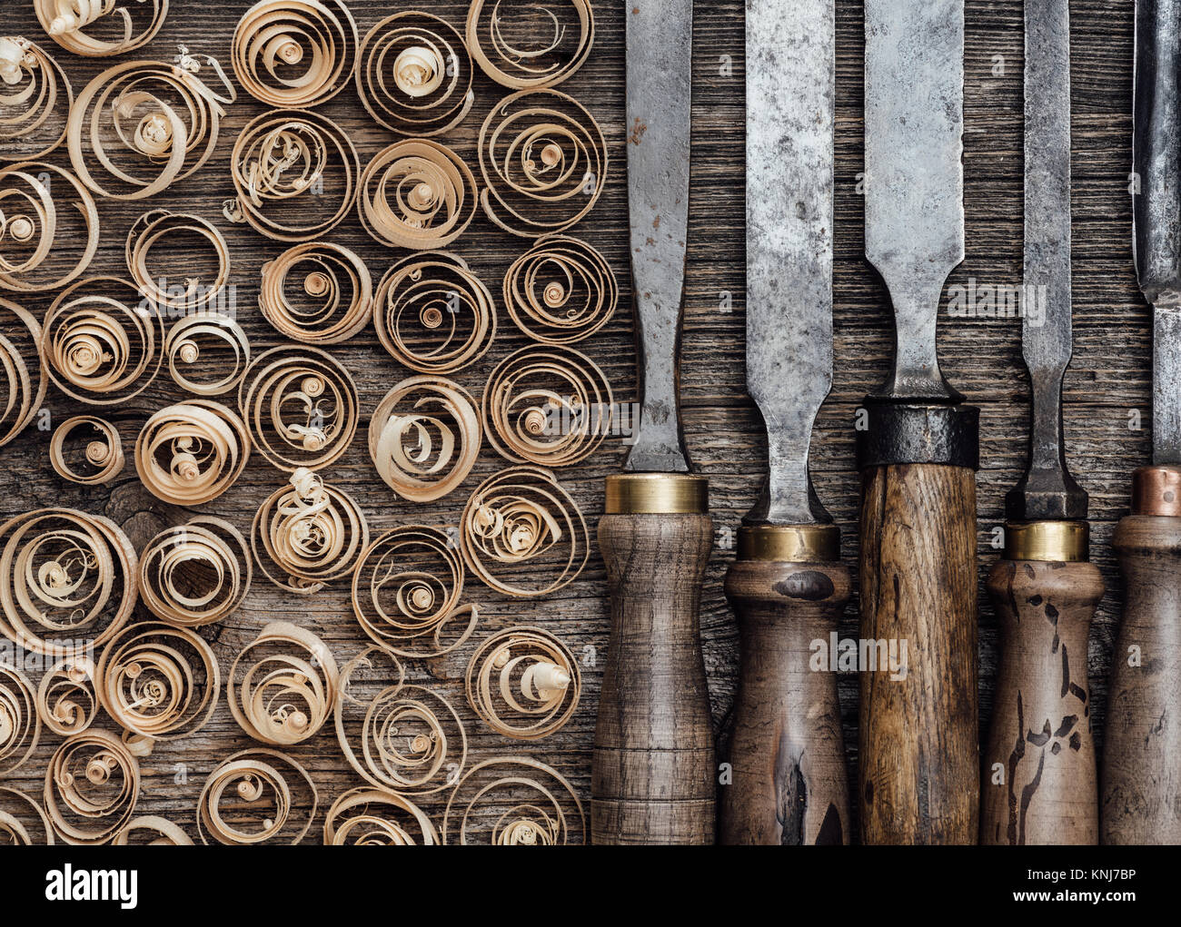 Set of used professional carving tools on the workbench and wood ...