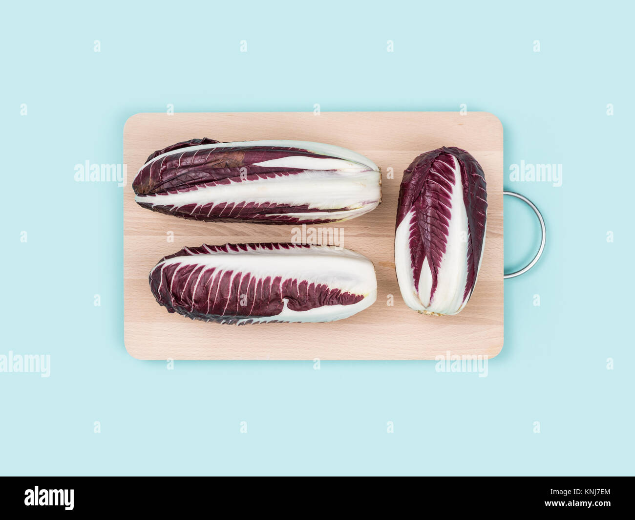 Fresh red chicory heads on a wooden chopping board, food preparation ...
