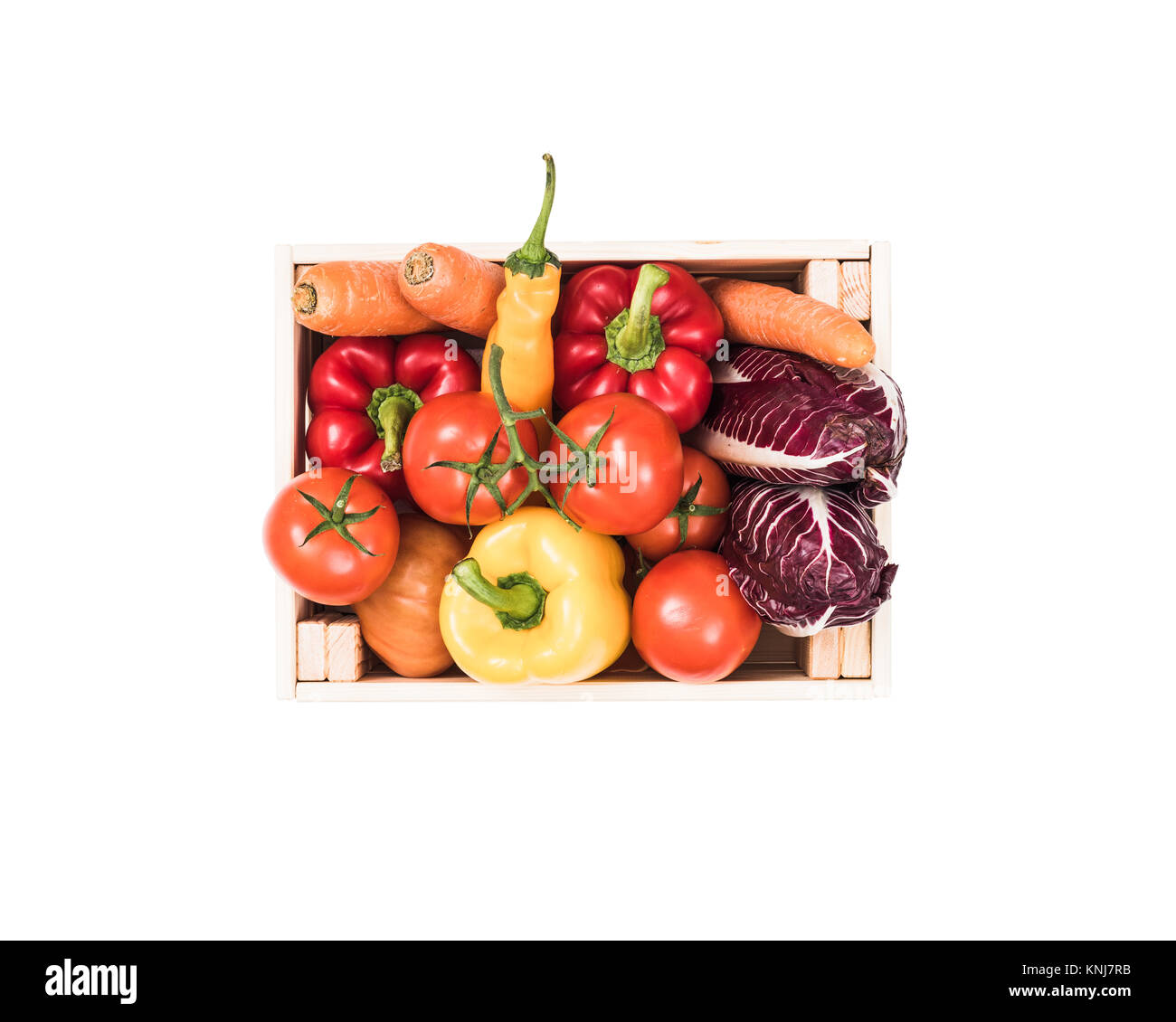 Fresh tasty red and yellow vegetables in wooden crates on white ...