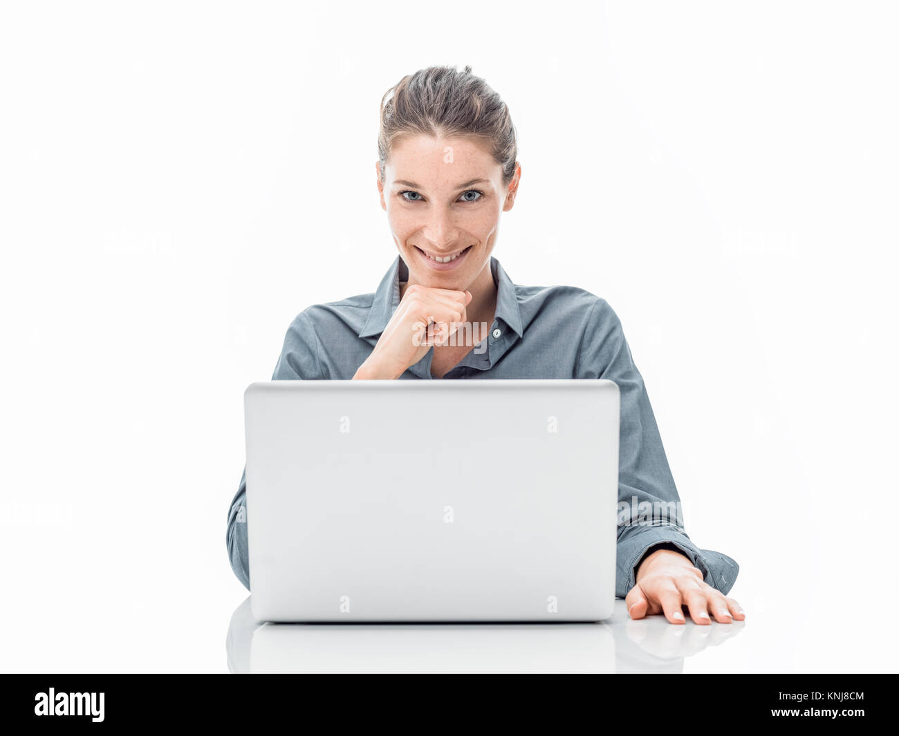 Confident efficient woman working with a laptop, she is smiling at ...