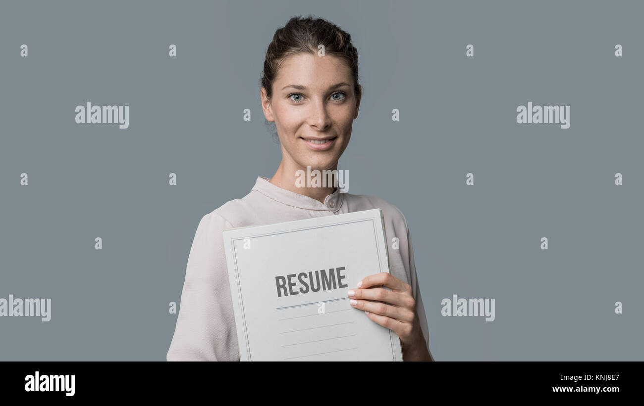 Young smiling cheerful woman holding her resume Stock Photo - Alamy