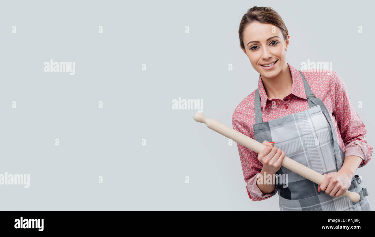 Young smiling housewife posing with rolling pin and apron Stock Photo ...