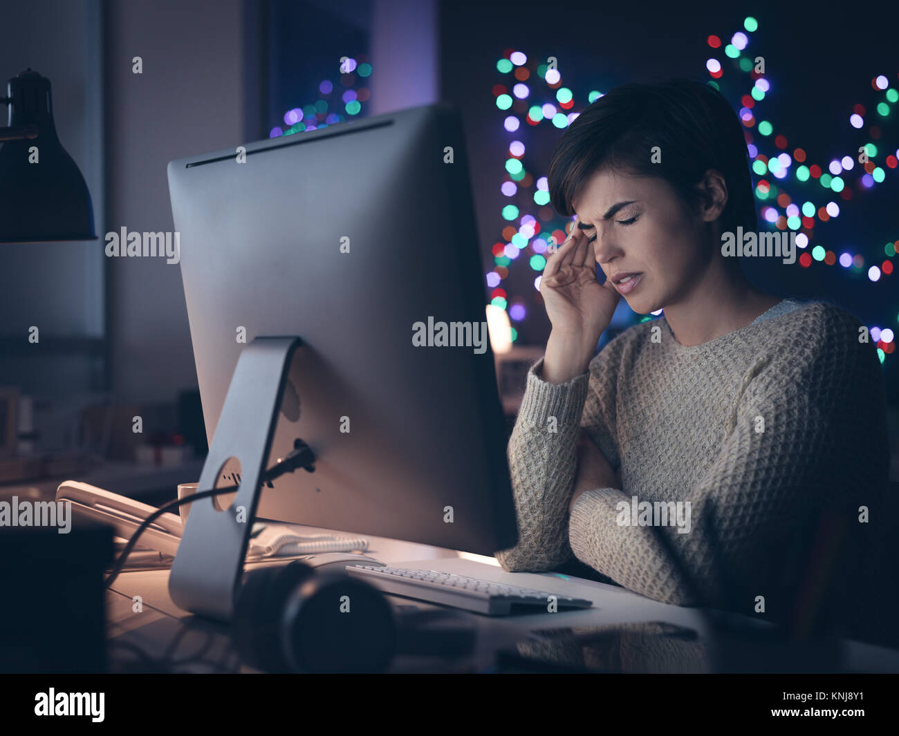 Young stressed woman working late at night with her computer and having ...