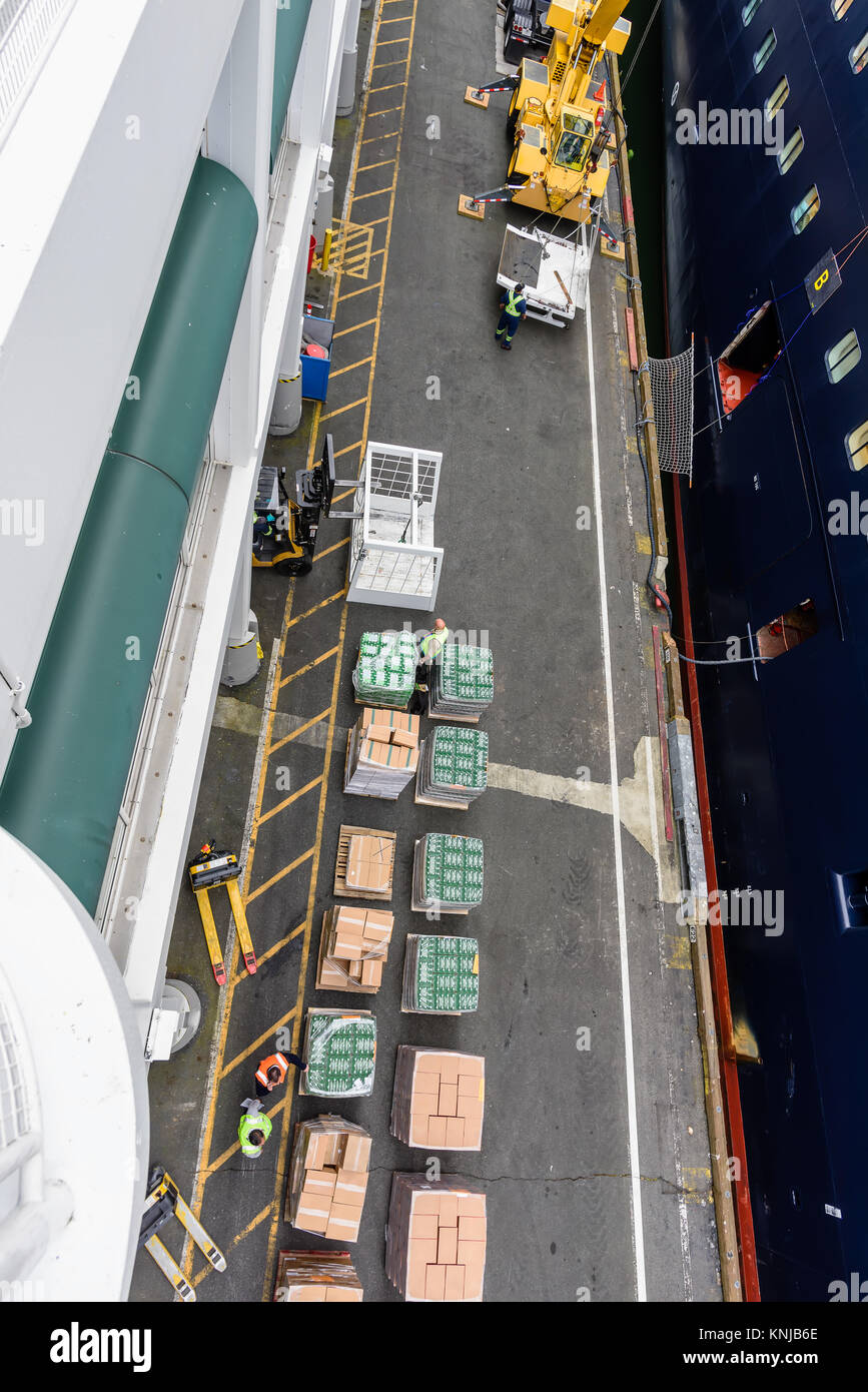 Loading workers in lifejackets of bottles with drinking water on a ship ...