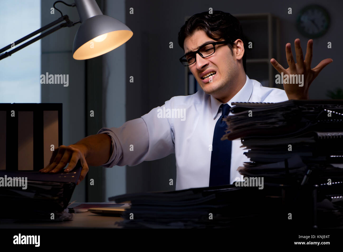 Young businessman working overtime late in office Stock Photo - Alamy