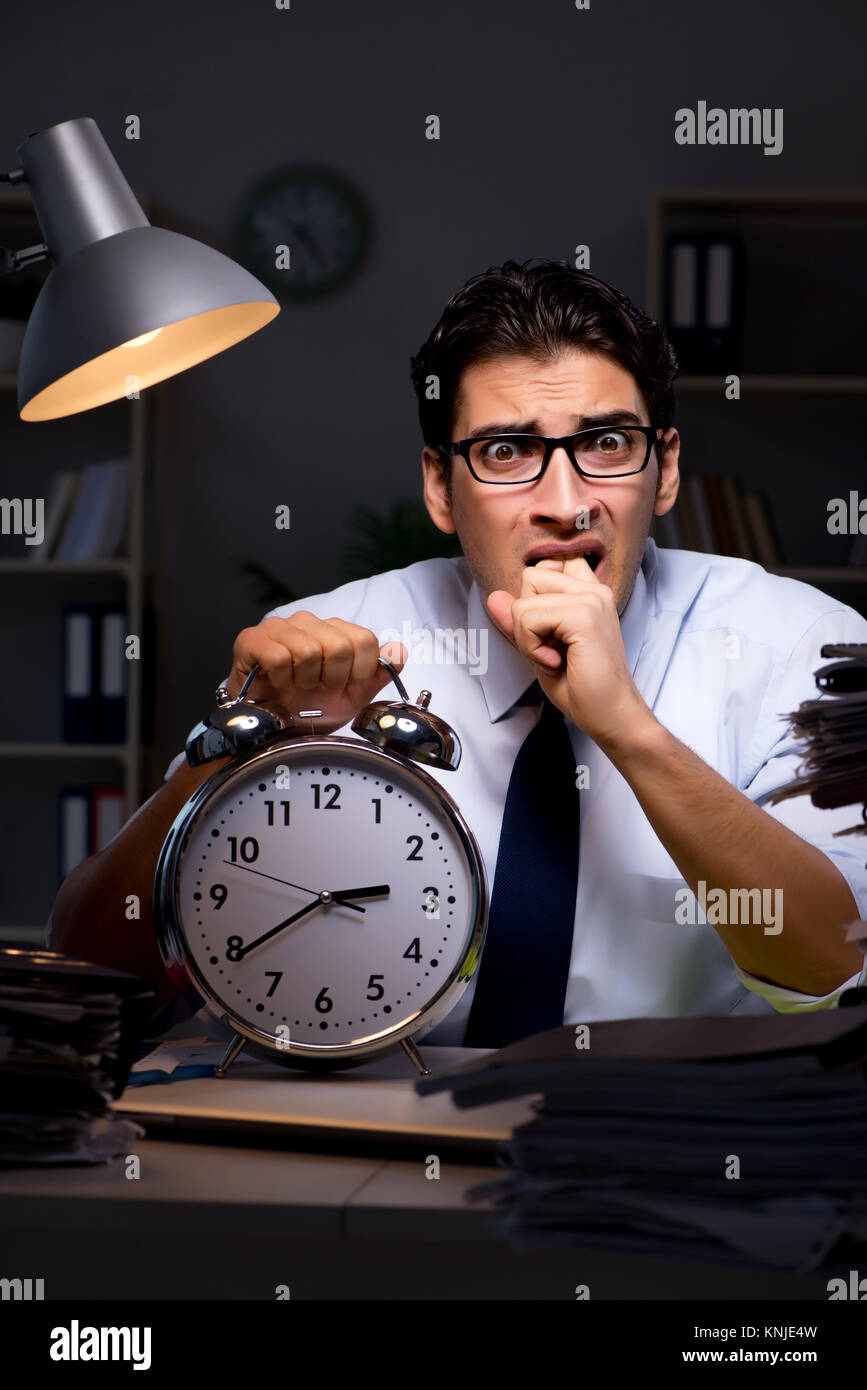 Young businessman working overtime late in office Stock Photo - Alamy