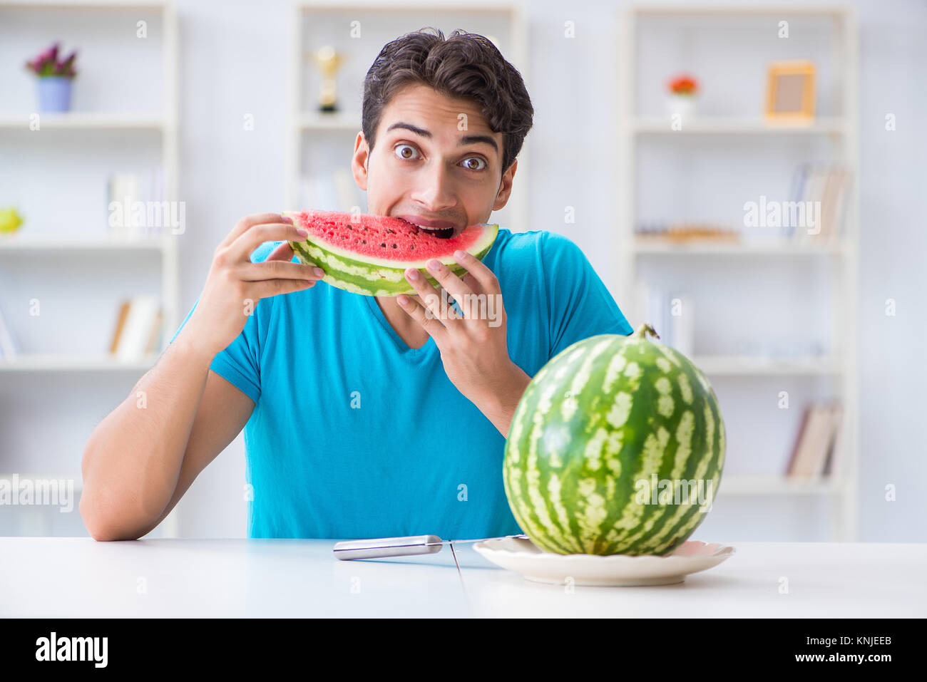 Man eating watermelon at home Stock Photo - Alamy