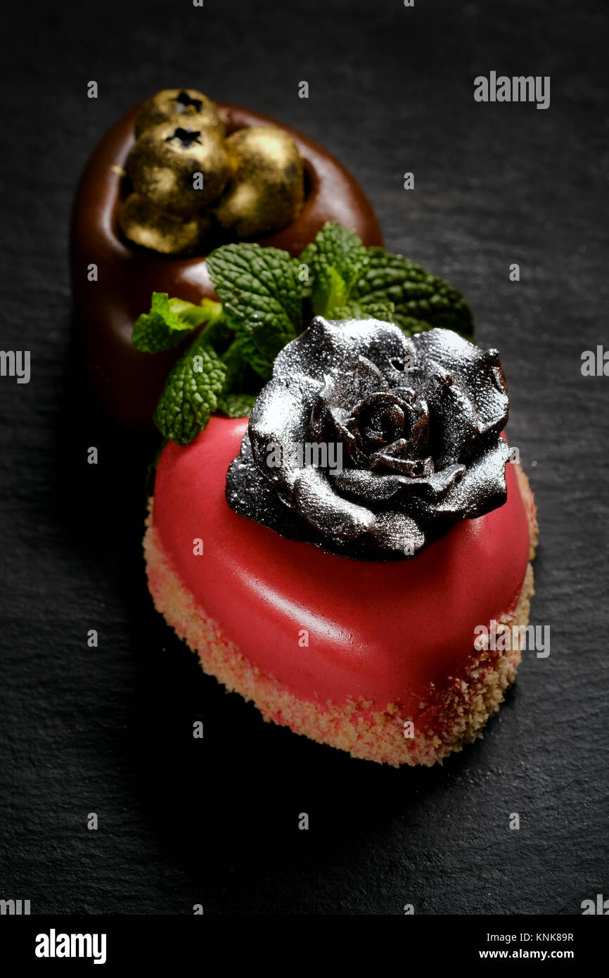 Two heart shaped cakes decorated with silver and gold sequin Stock ...