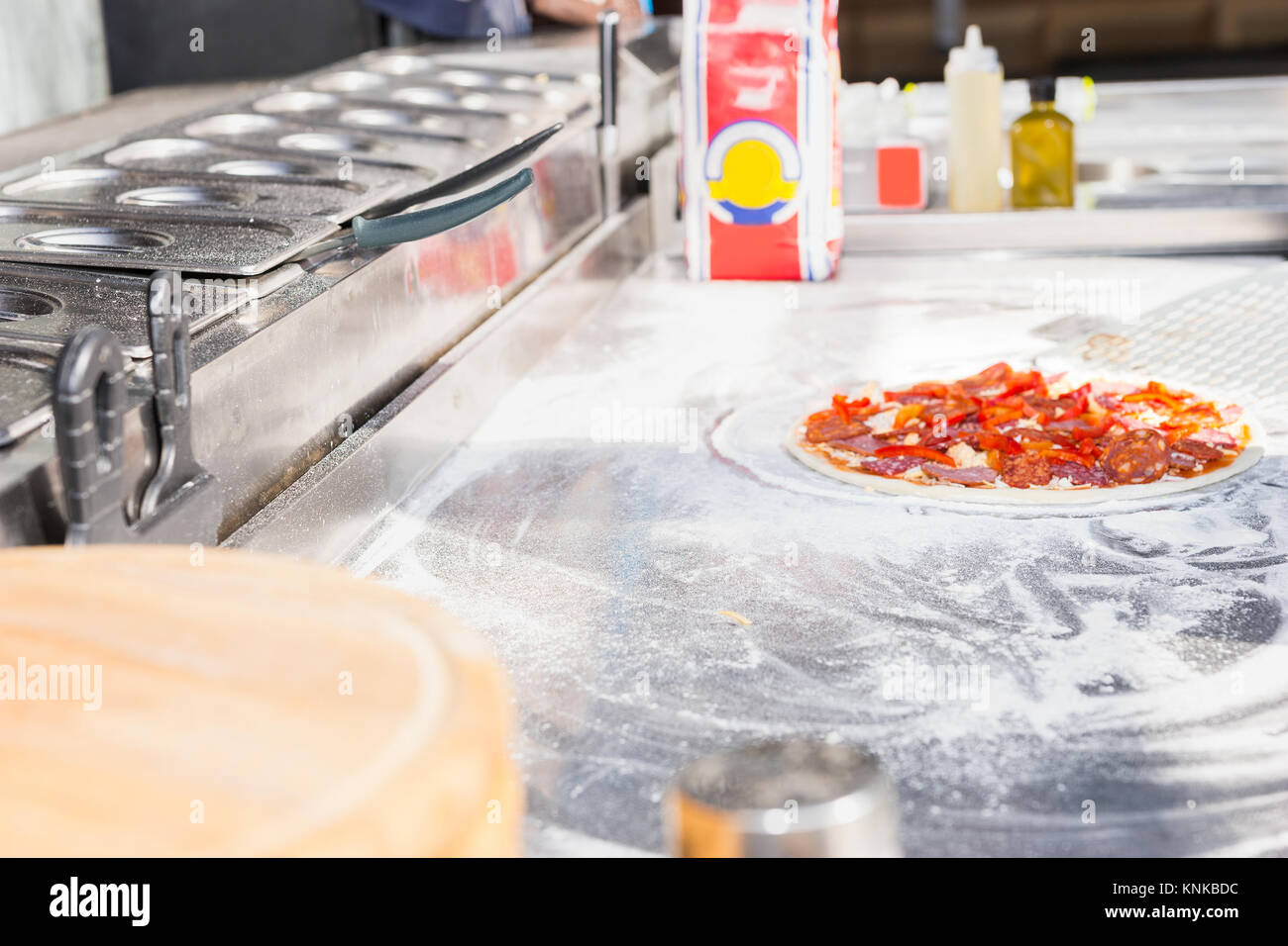 Raw pizza with many fillings on the kitchen surface with flour. Food ...