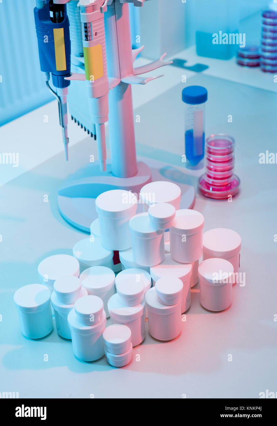 Pile of pill containers on laboratory bench with some cell culture ...