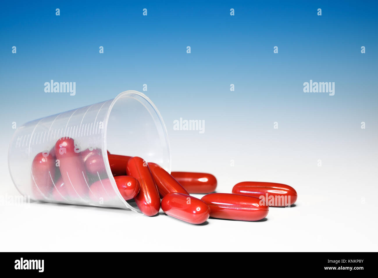 Closeup on dark red capsules with medication on blue gradient ...