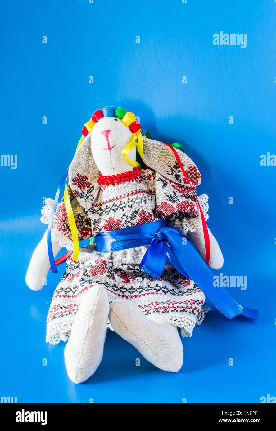 The doll is a guard in a national costume with ribbons. On a blue ...