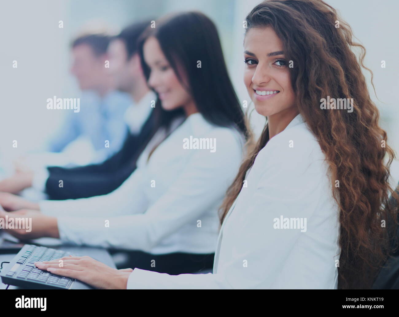 Happy young businesswoman looking behind and her colleagues work Stock ...