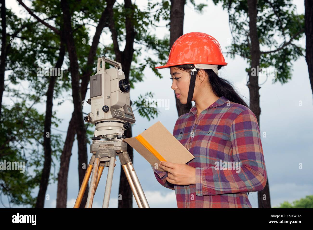 Female surveyor or Engineer making measure by Theodolite on the street ...