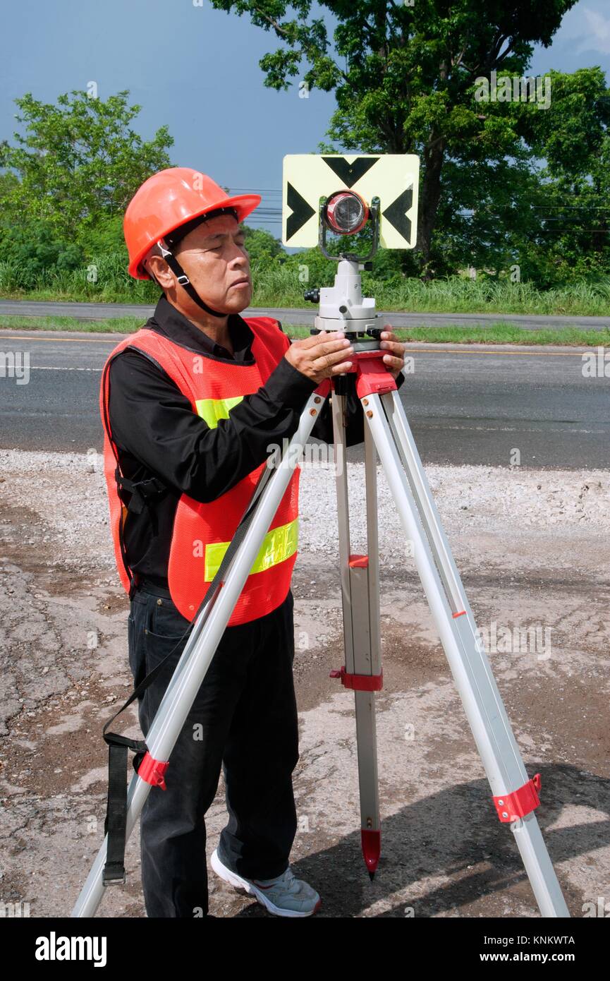 Surveyor or Engineer setting measure prism reflector on the highway in ...