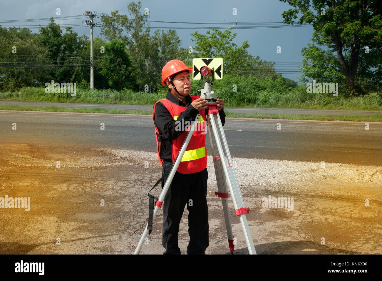Surveyor or Engineer setting measure prism reflector on the highway in ...
