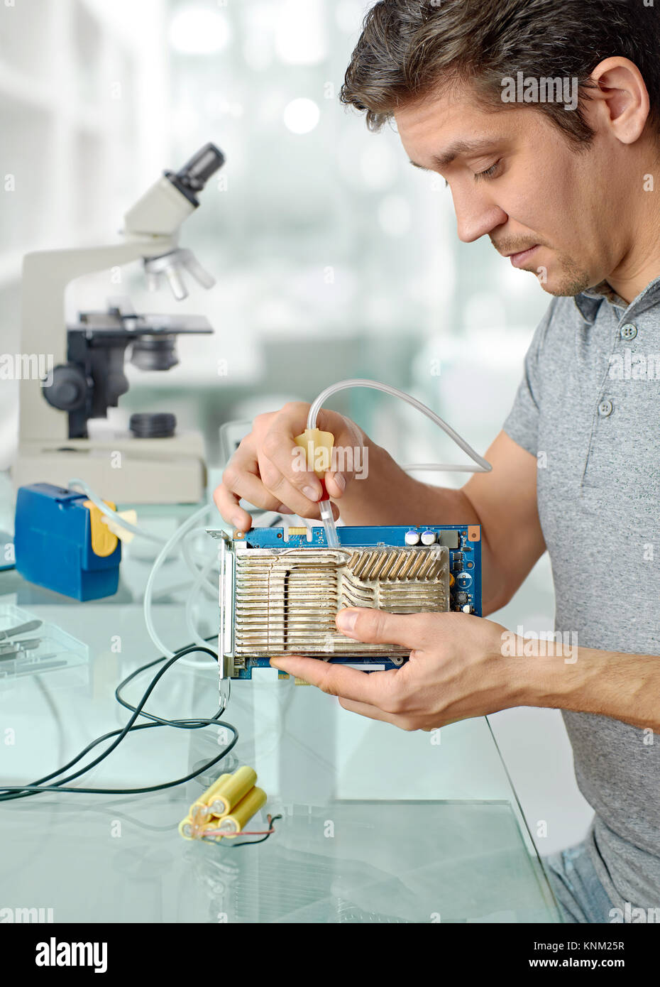 Young male tech cleans faulty computer processor in hardware repair ...