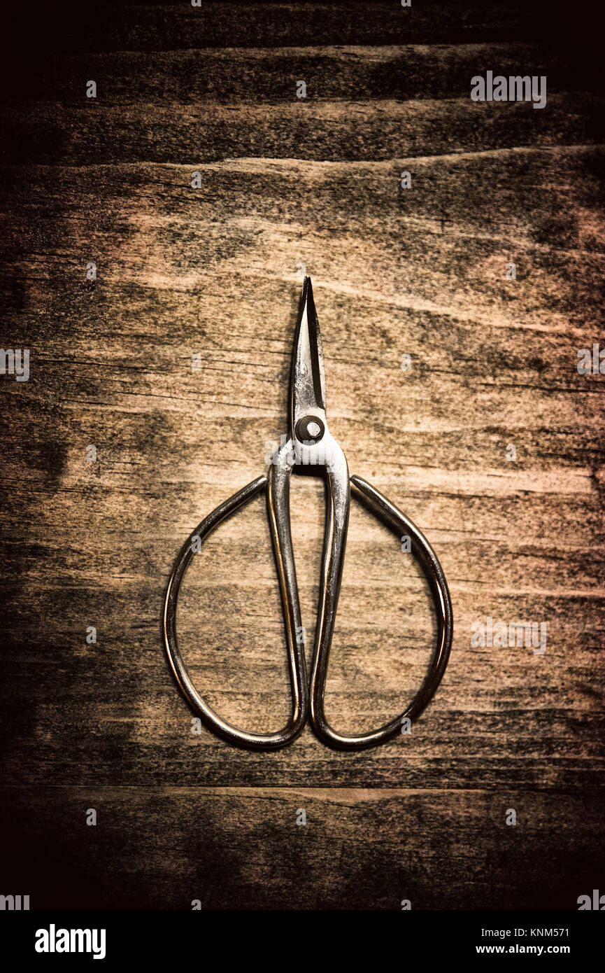 Old pair of scissors on wooden background Stock Photo - Alamy