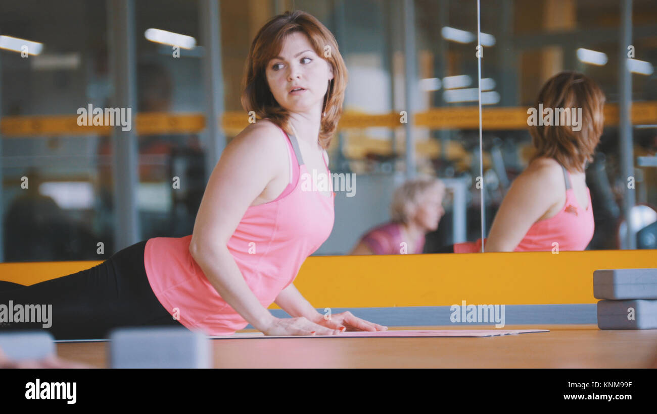 Athletic female shows yoga exercises for women in fitness club Stock ...