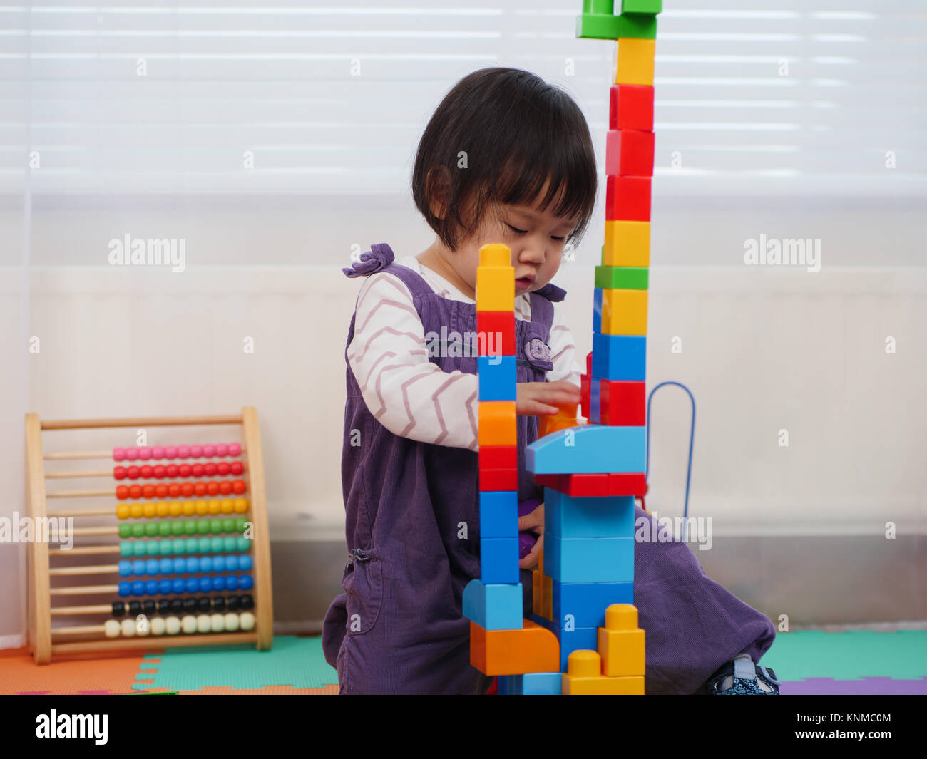Baby girl play building blocks at home Stock Photo - Alamy