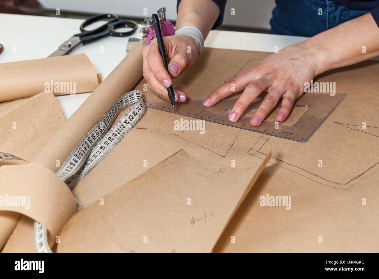 Seamstress is cutting drawing for a dress with scissors. Style and ...