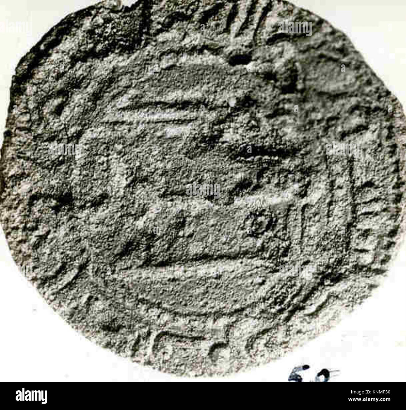 A circular metallic coin with inscriptions and motifs, historically ...