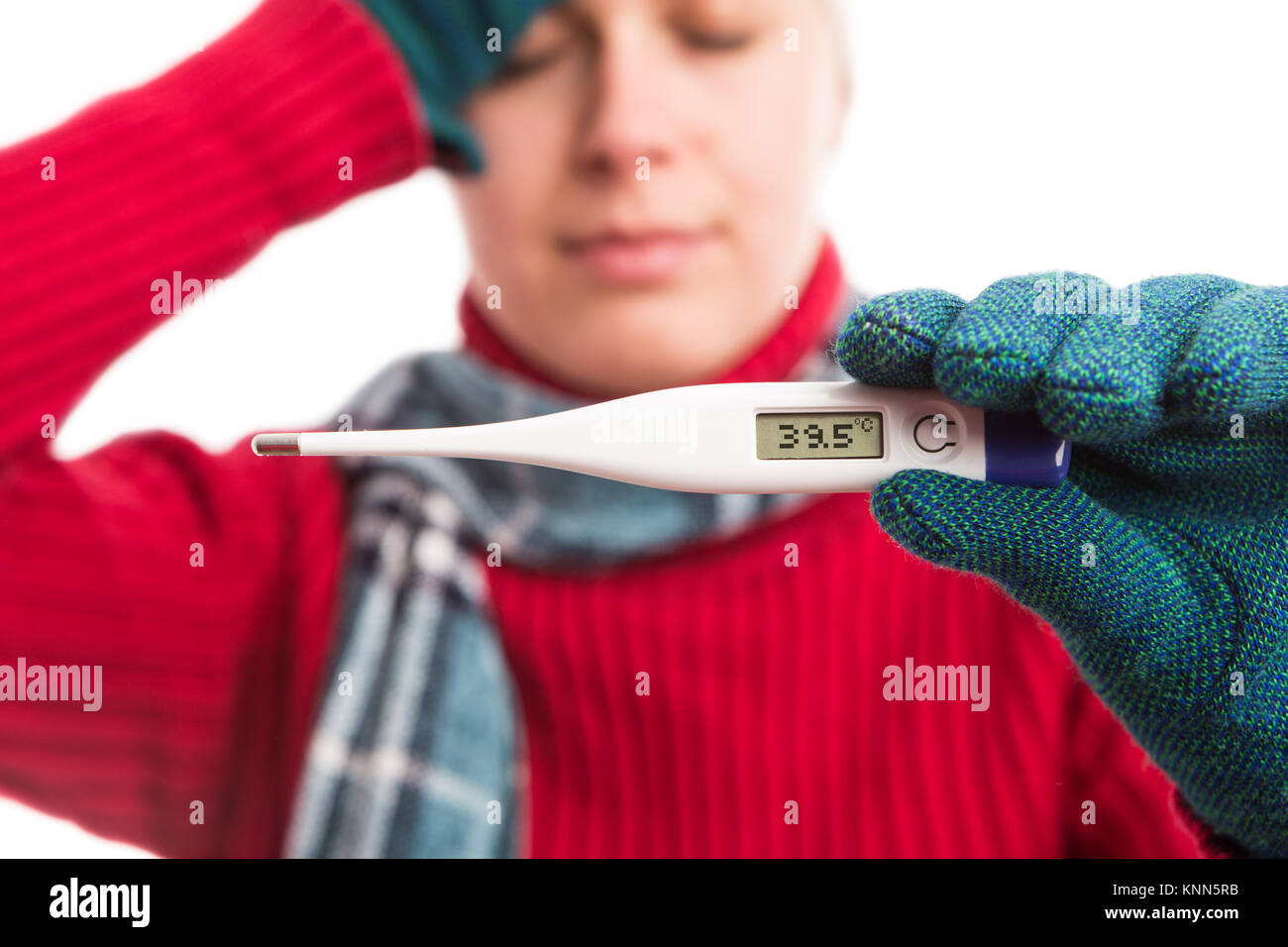 Sick cold woman showing thermometre with high temperature wearing warm ...