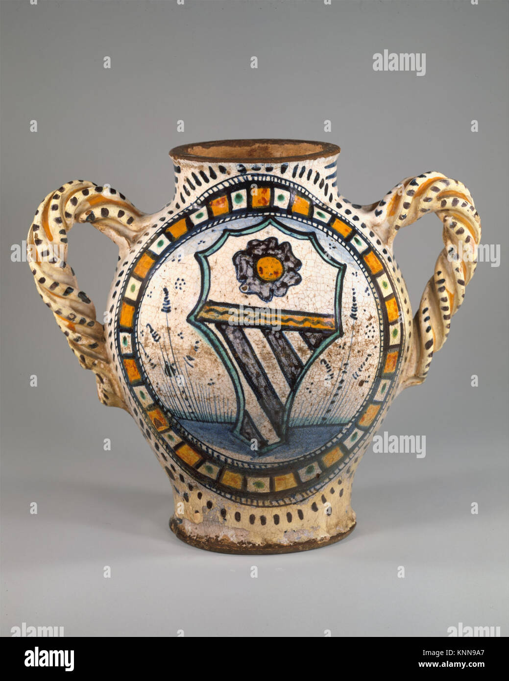 This armorial jug displays heraldic symbols on a ceramic vessel ...