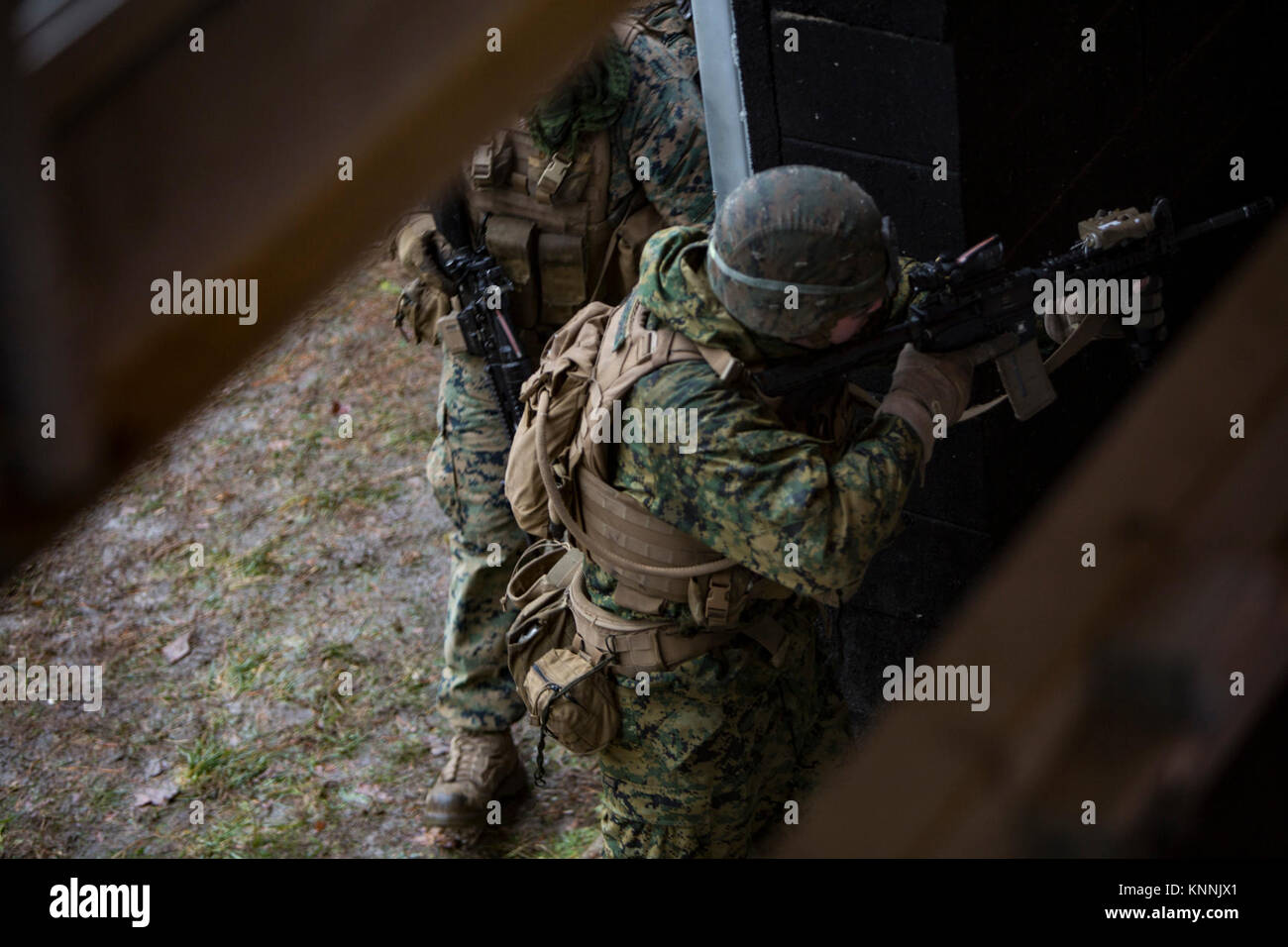 U.S. Marines with Company G., 2nd Battalion, 8th Marine Regiment, check araound a corner before ...