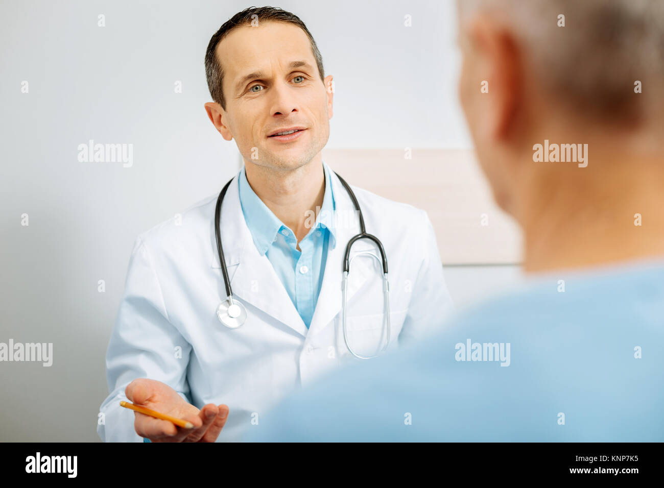 Nice male doctor explaining the diagnosis Stock Photo - Alamy
