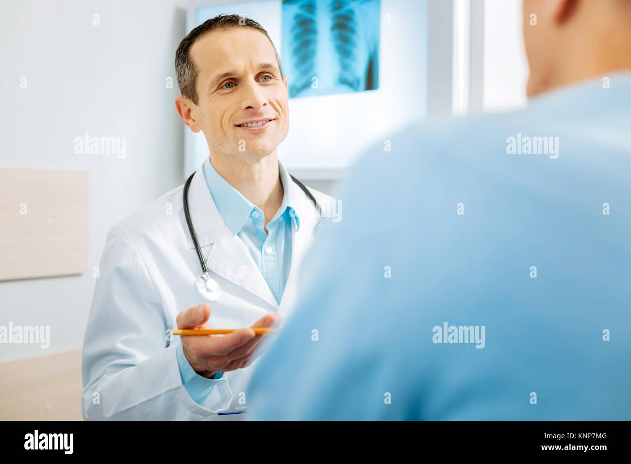 Cheerful friendly doctor smiling Stock Photo - Alamy