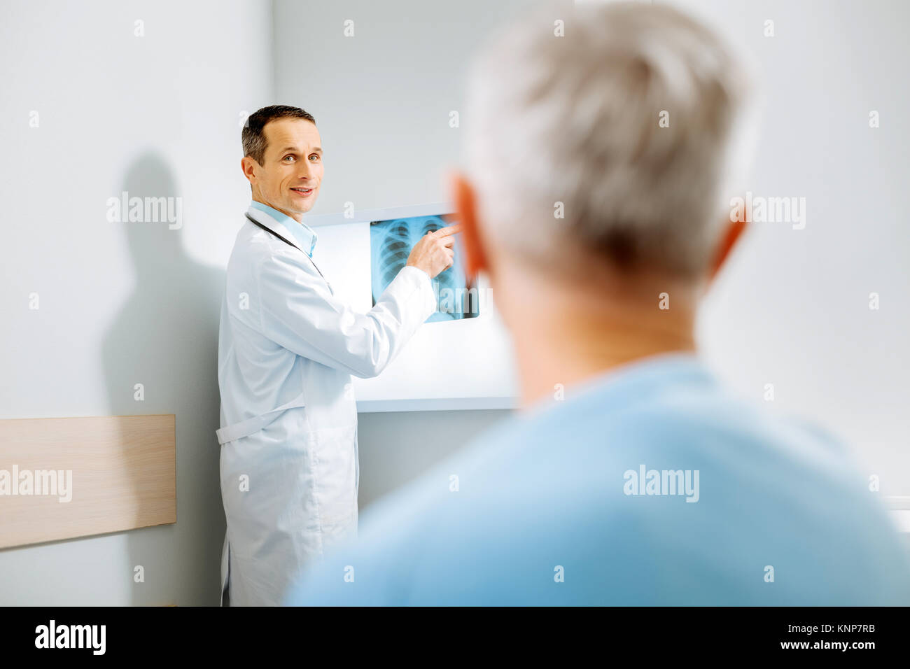 Cheerful positive doctor standing near the X ray image Stock Photo - Alamy