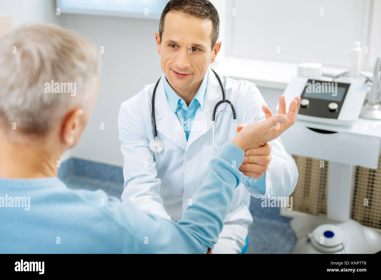 Nice positive doctor speaking to the patient Stock Photo - Alamy